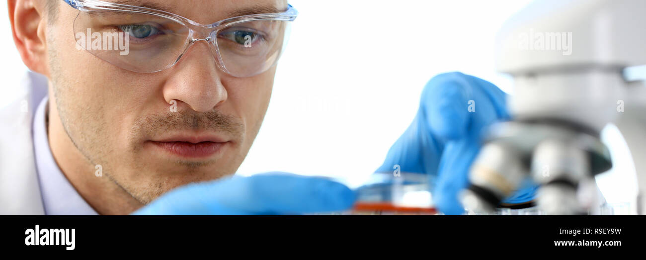 A male chemist holds test tube of glass in his hand Stock Photo - Alamy
