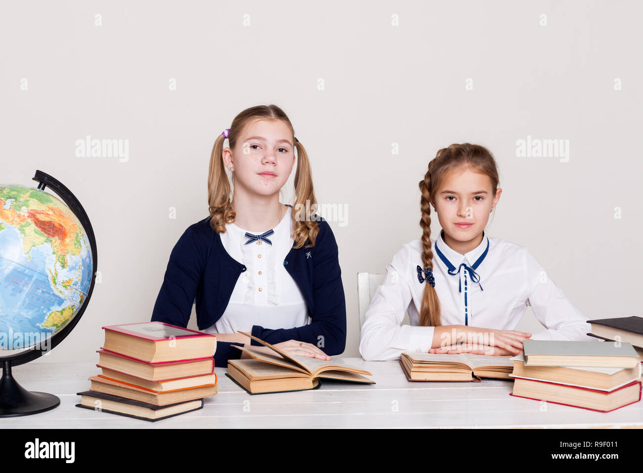 two girls in the classroom Learn lesson books at her desk globe Stock ...