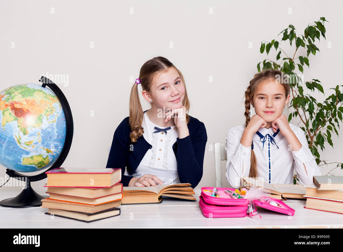 two girls in the classroom Learn lesson books at her desk globe Stock ...