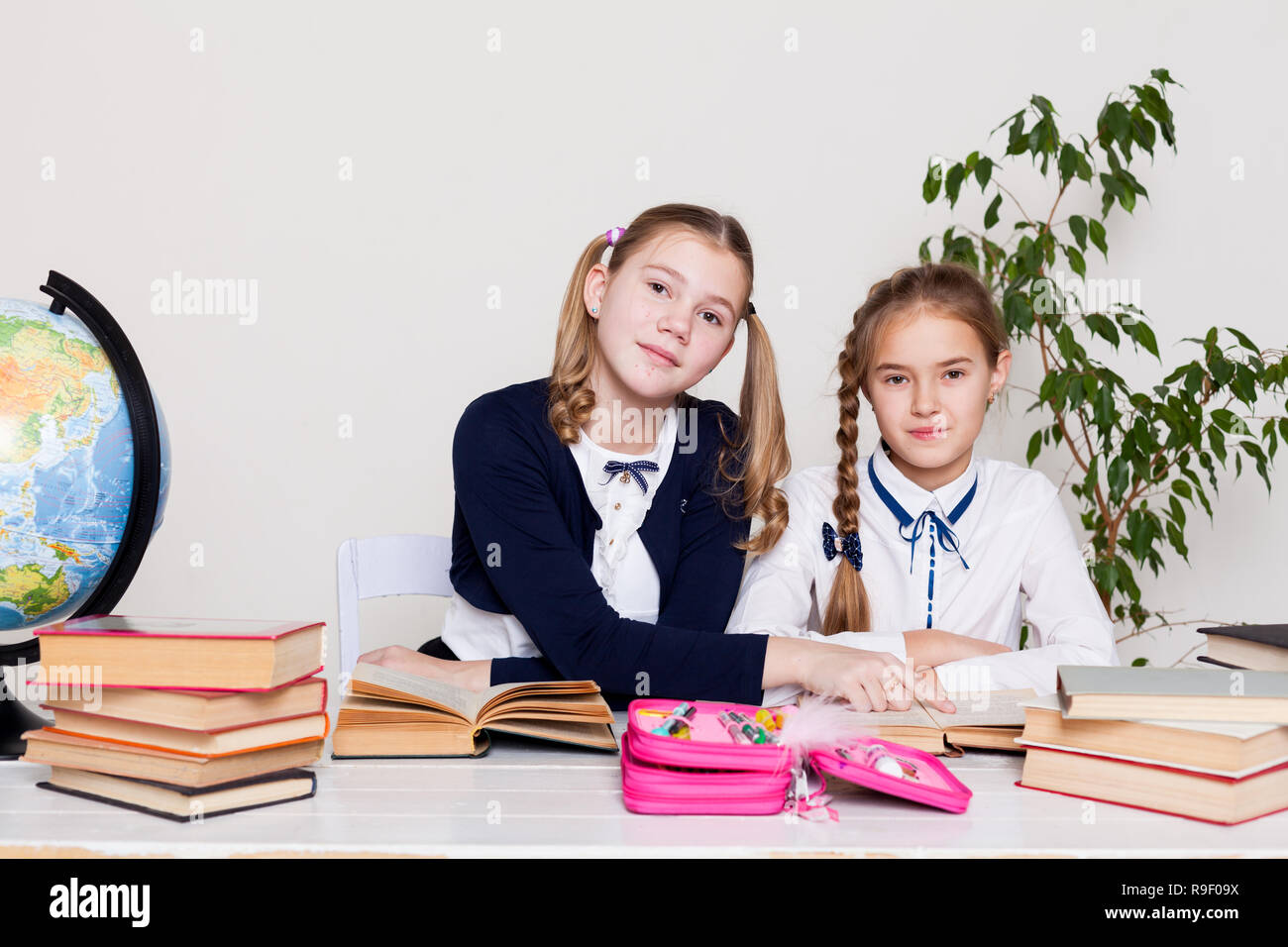 two girls in the classroom Learn lesson books at her desk globe Stock ...