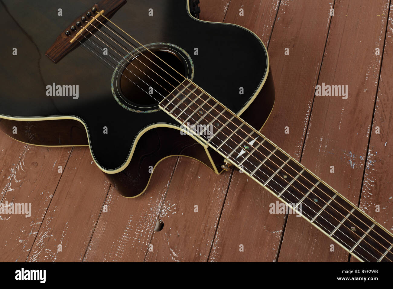 Musical instrument - Fragment brown cutaway acoustic guitar on a wood ...