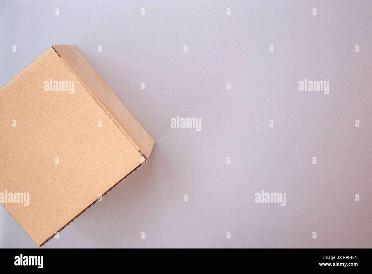 Corner of closed big square cardboard craft gift box on the silver gray ...