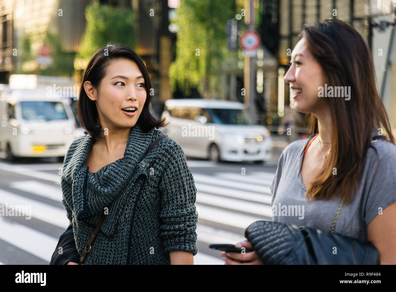 Two girlfriends meeting outdoors and having fun - Japanese people ...