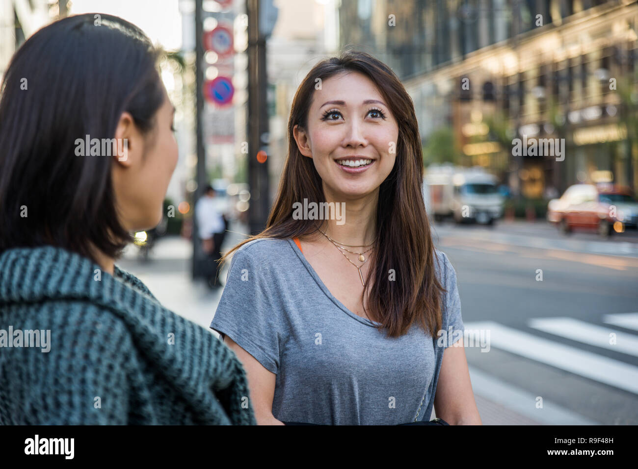 Two girlfriends meeting outdoors and having fun - Japanese people ...