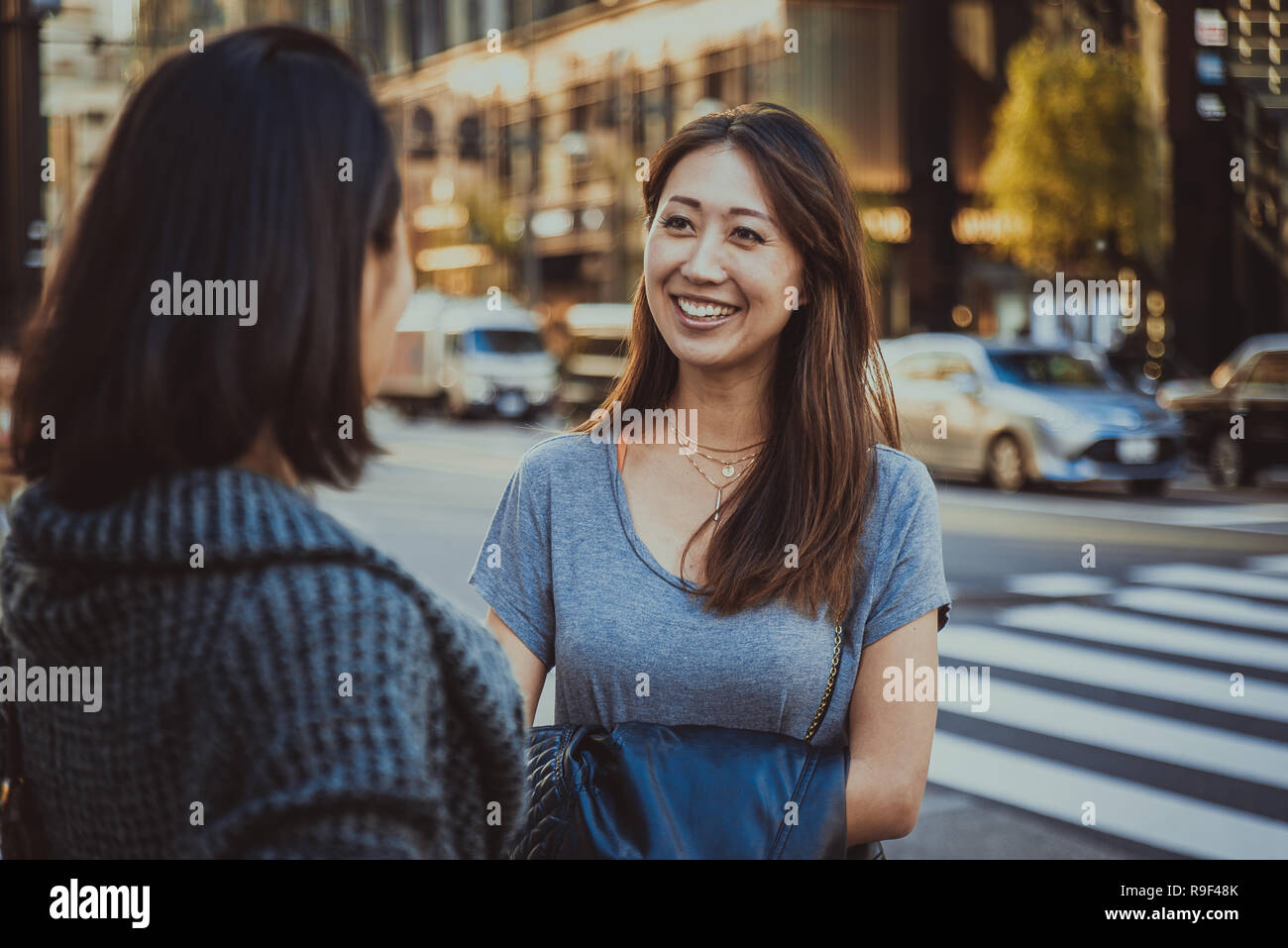 Two girlfriends meeting outdoors and having fun - Japanese people ...