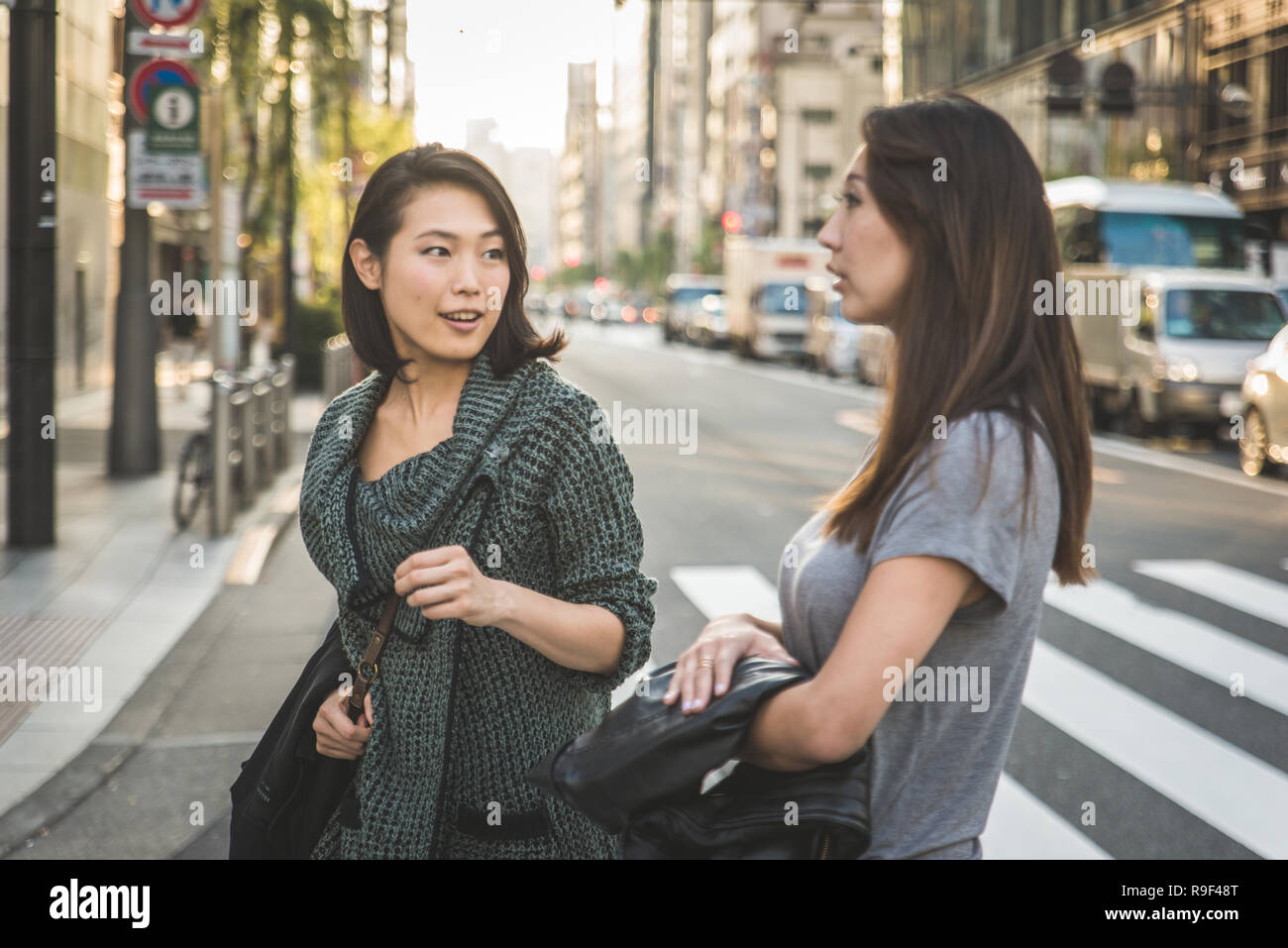 Two girlfriends meeting outdoors and having fun - Japanese people ...