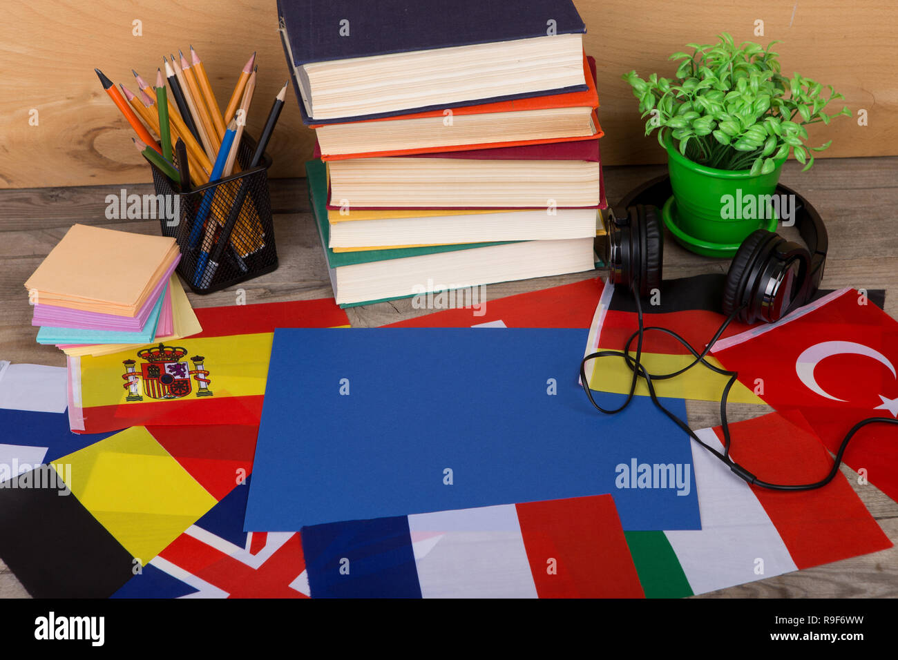 Learning languages concept - blank paper, flags, books, headphones ...
