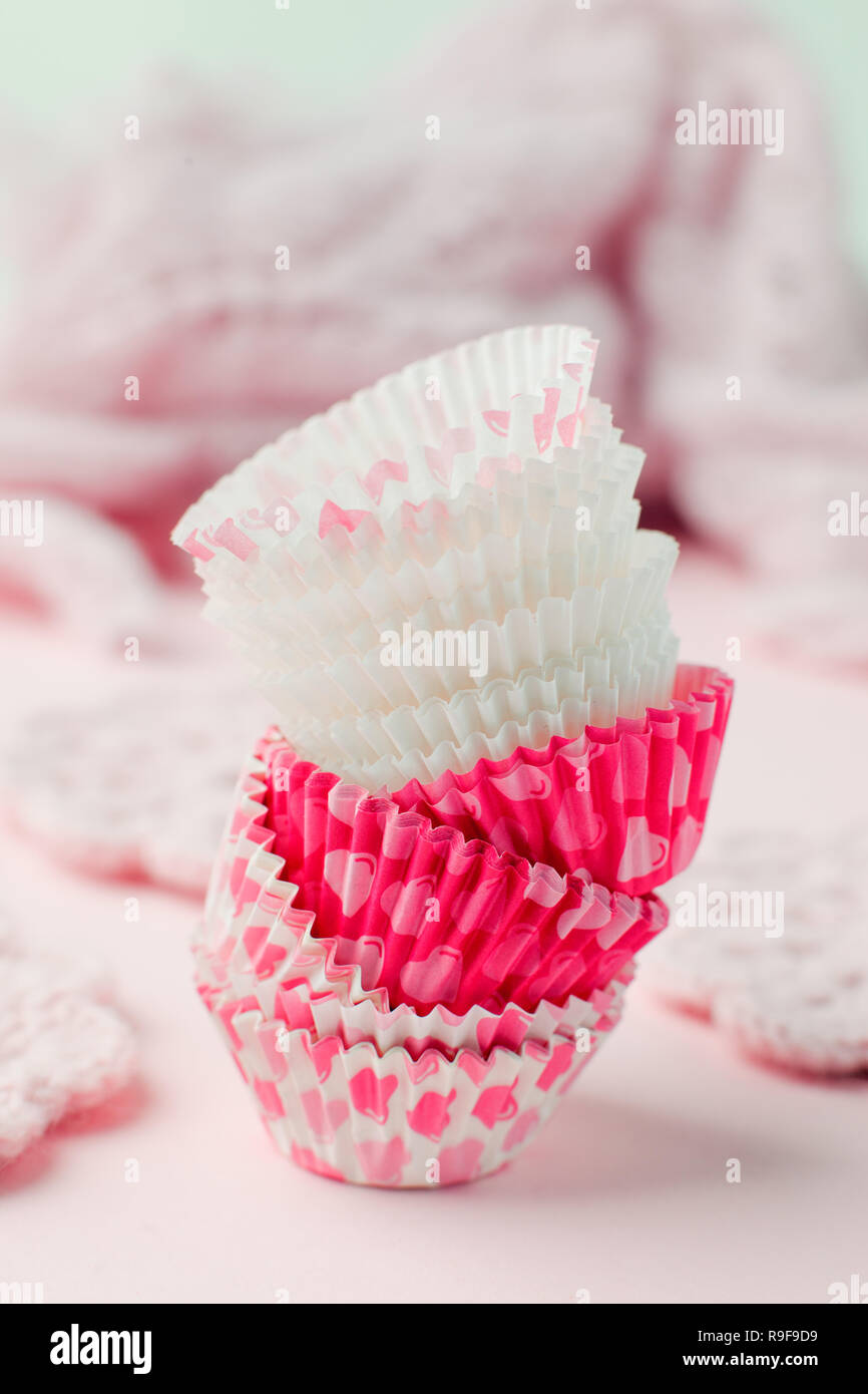 Cupcake cases tower in variety of color and size on pink table ready ...