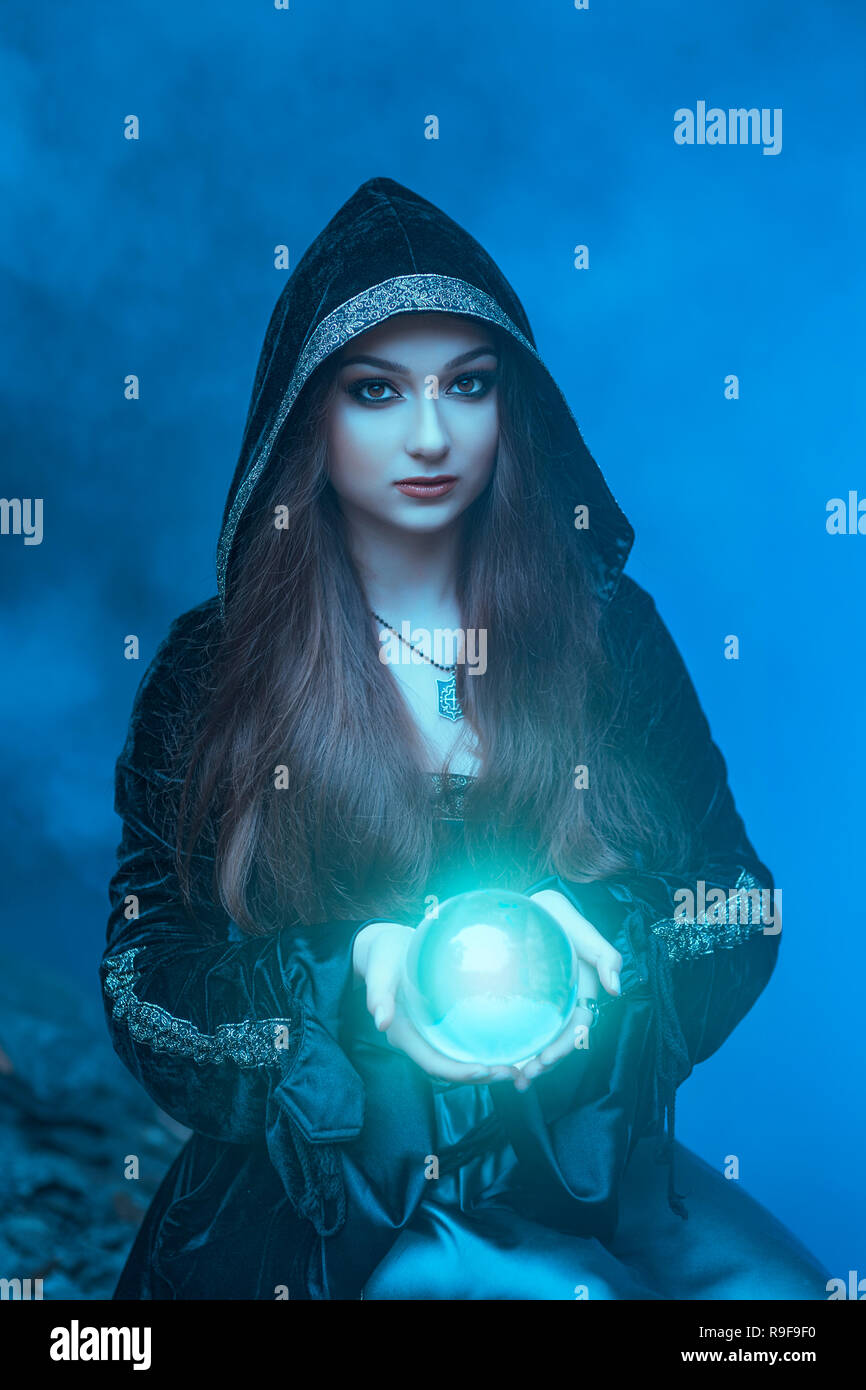 The witch with magic ball in her hands causes a spirits Stock Photo - Alamy
