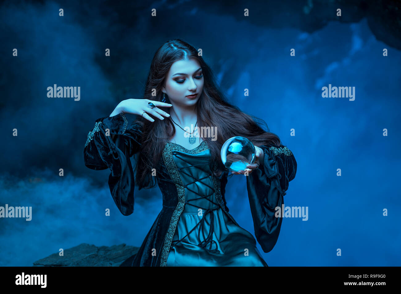 The witch with magic ball in her hands causes a spirits Stock Photo - Alamy