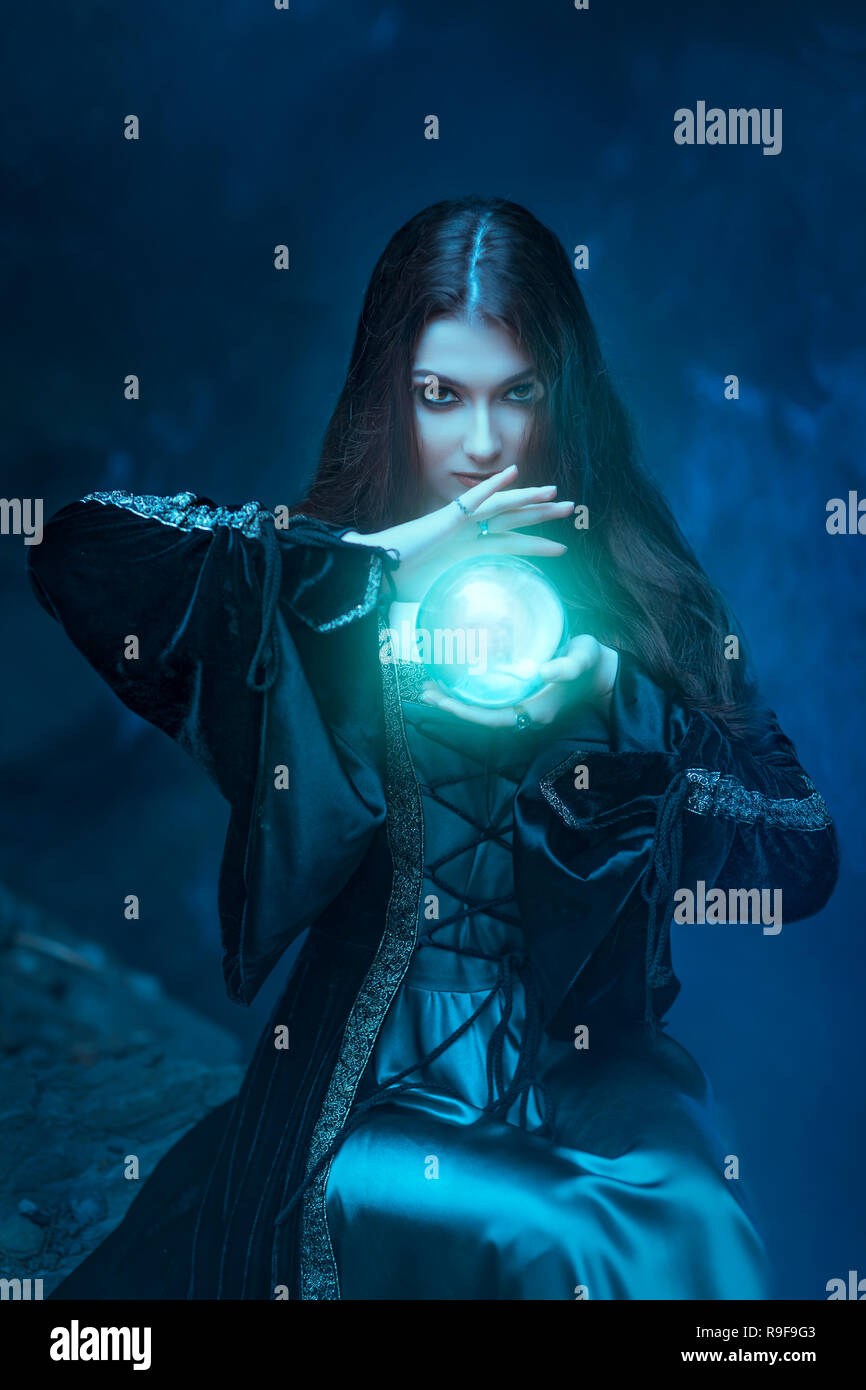 The witch with magic ball in her hands causes a spirits Stock Photo - Alamy