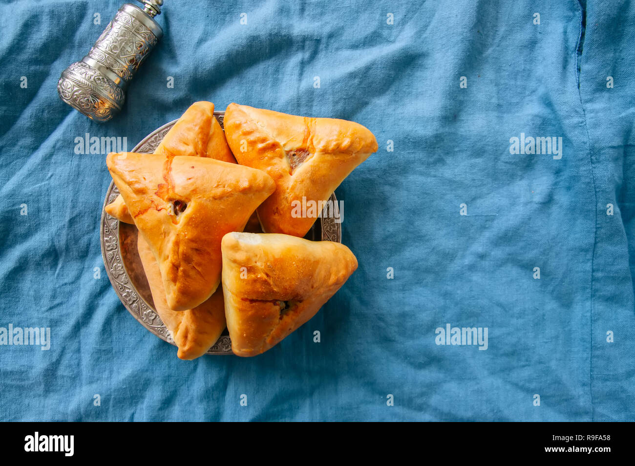 Homemade baked uchpuchmak (samsa) with meat and potato served on a ...