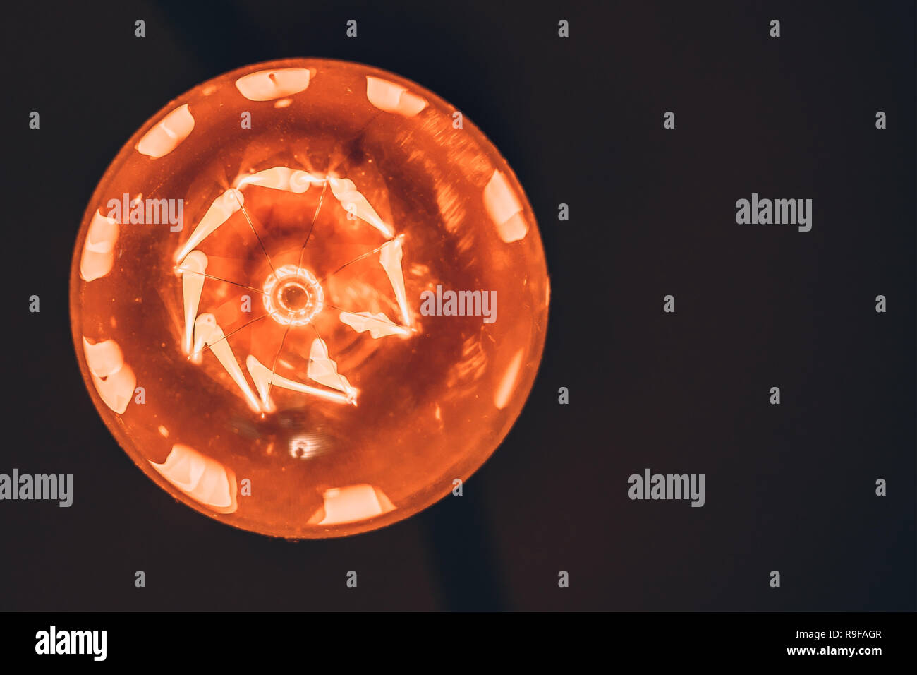 Orange edison's light bulb in the dark. Top view Stock Photo - Alamy