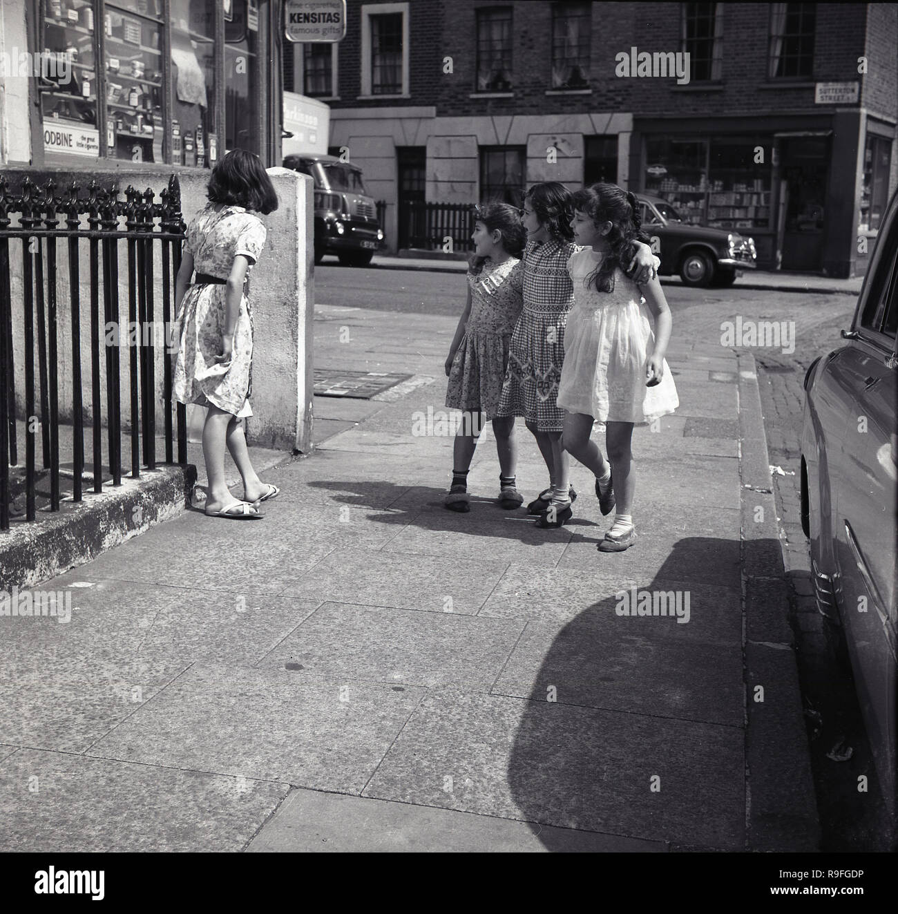 1960s, children, young girls, playing together on the pavement in ...