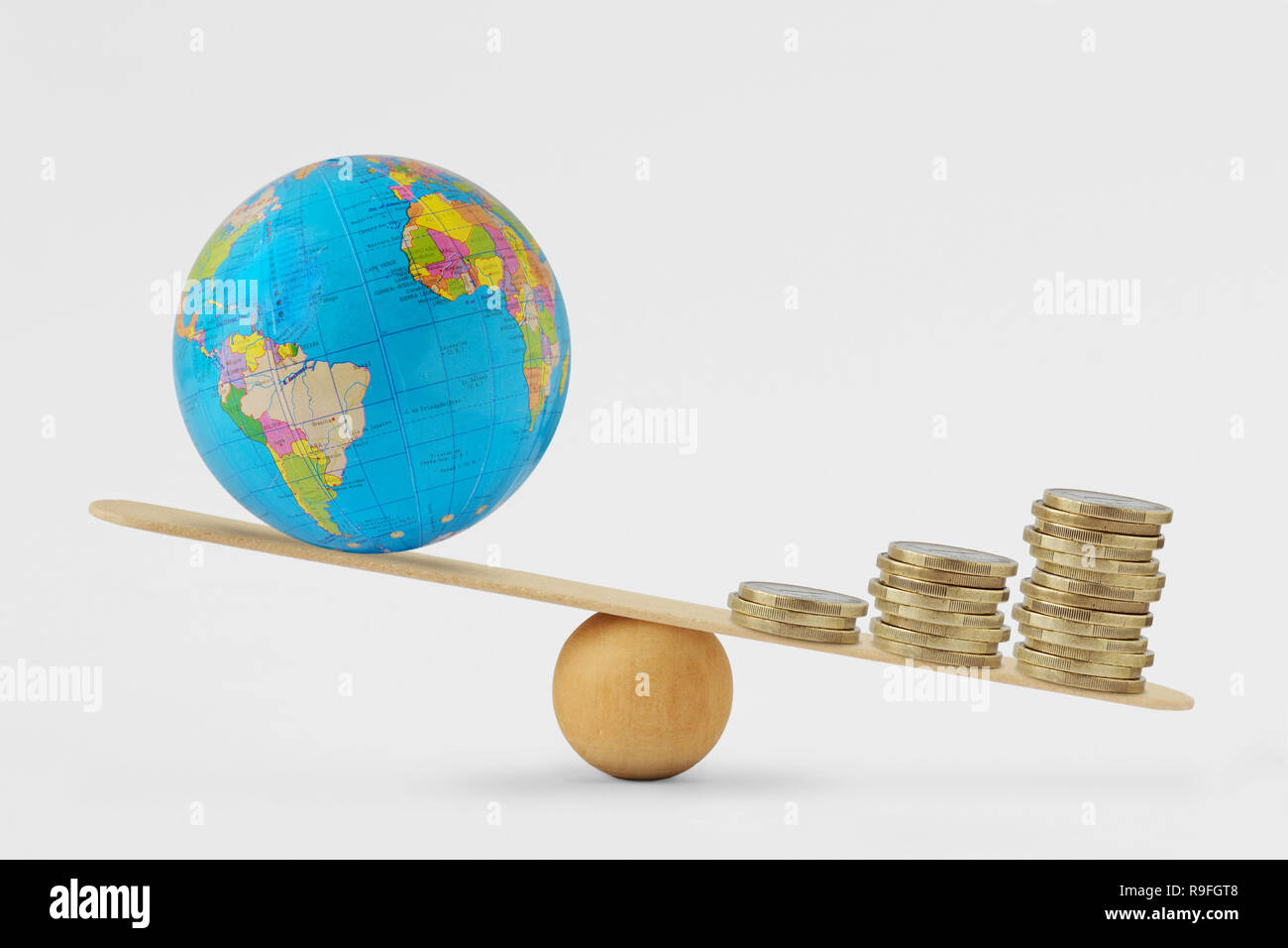 World globe and coins stack on balance scale - Concept of economic ...