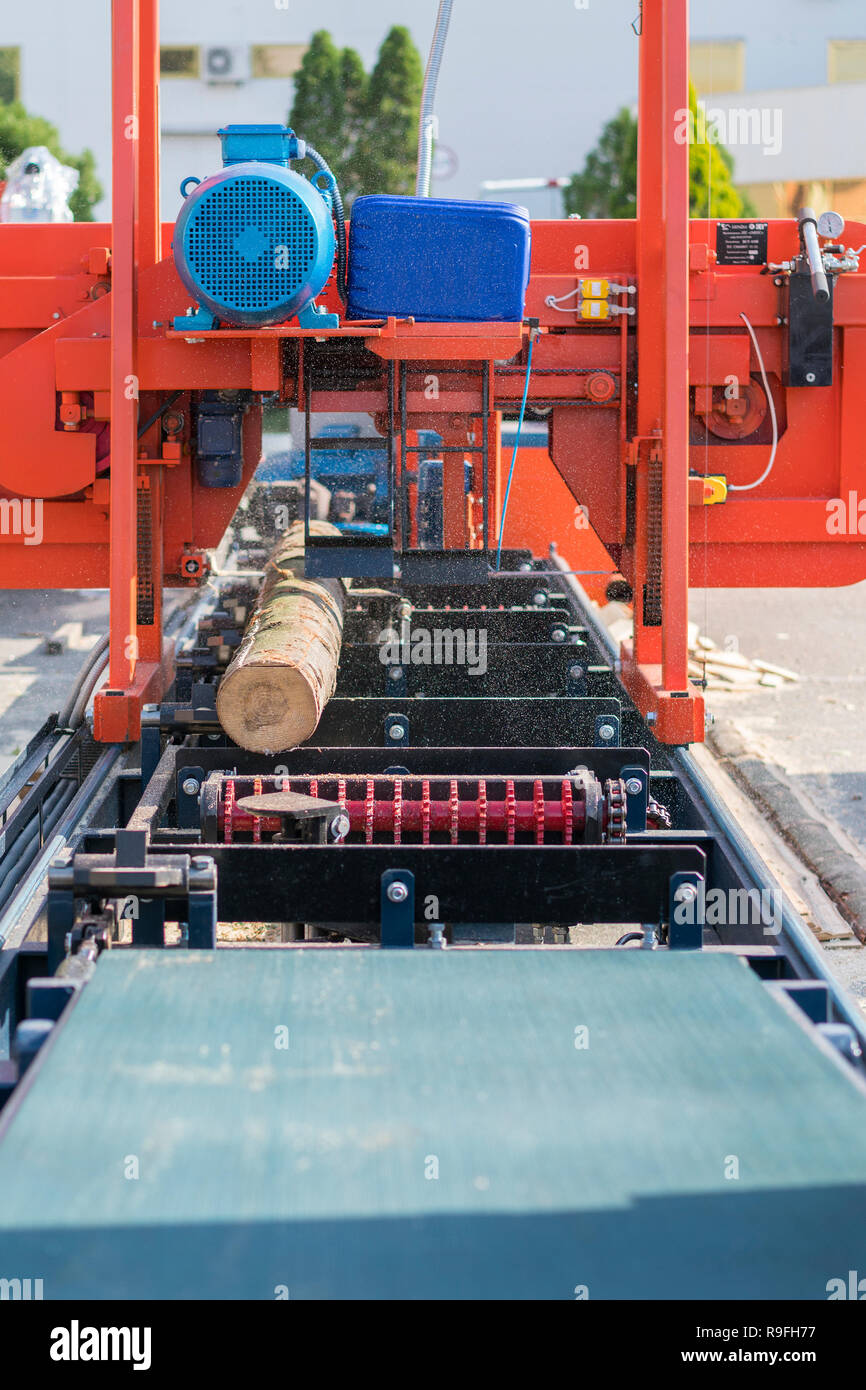 woodworking enterprise. Wood Cutting Machine. Partially milled log on a ...