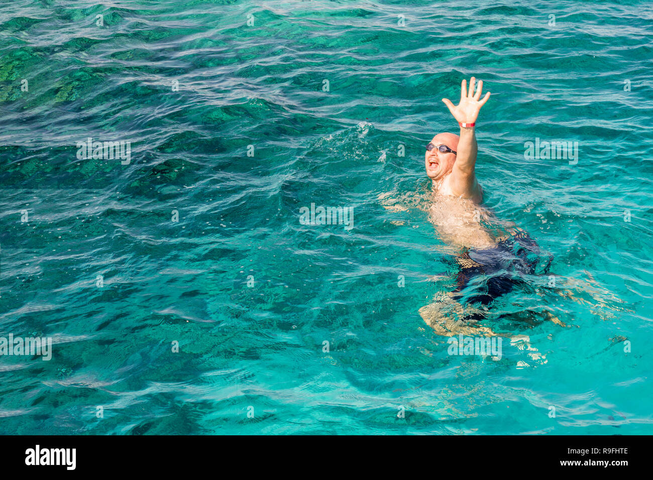 Drowning man in sea asking for help with raised arms. The man is ...