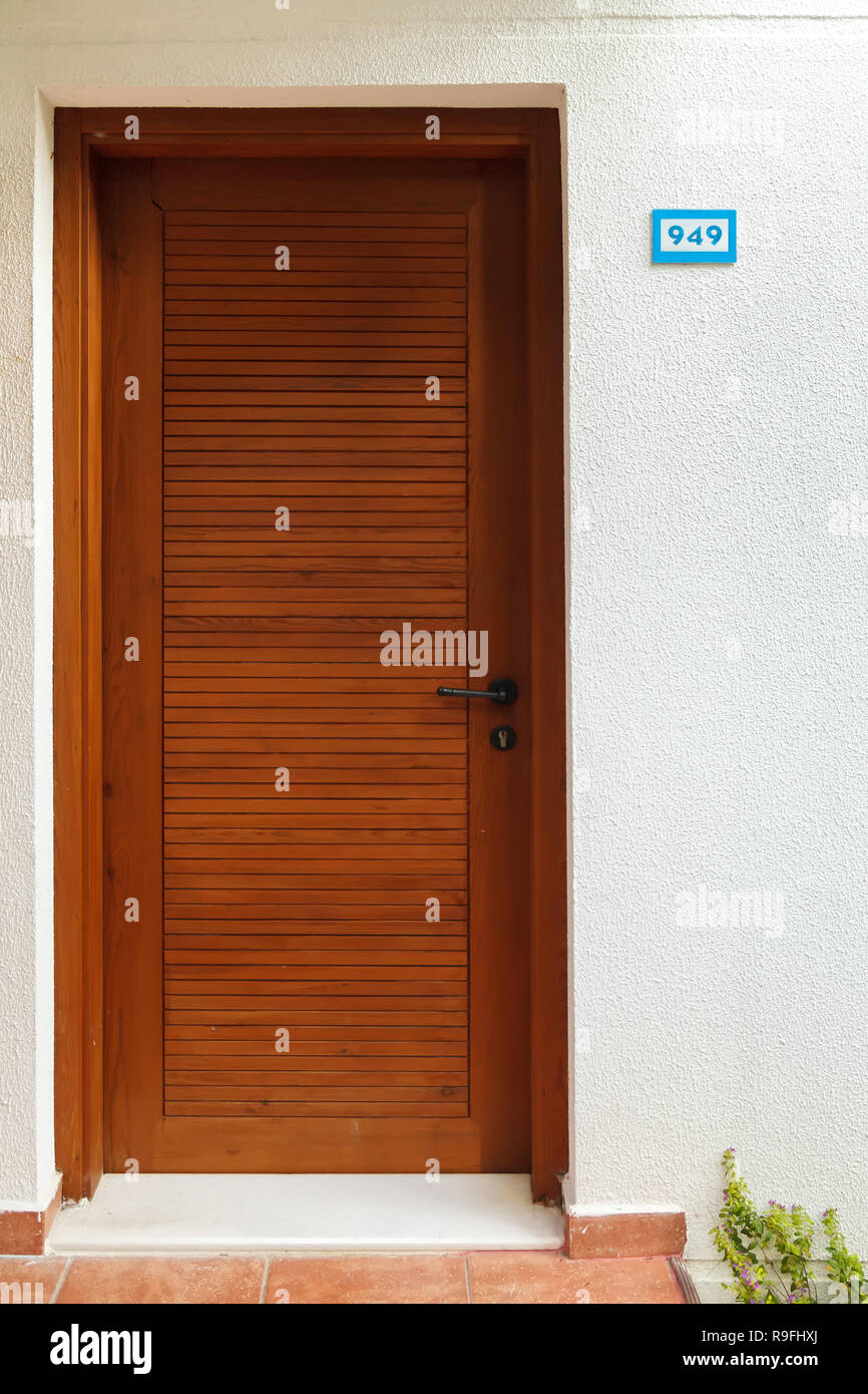 Brown wooden door to a club-style hotel room with pointer 949. Vertical ...