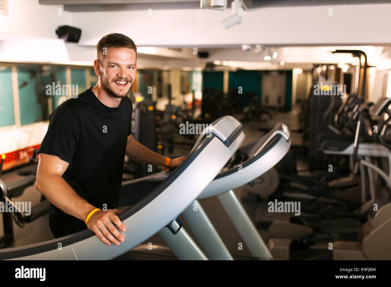 happy guy walking on a treadmill Stock Photo - Alamy