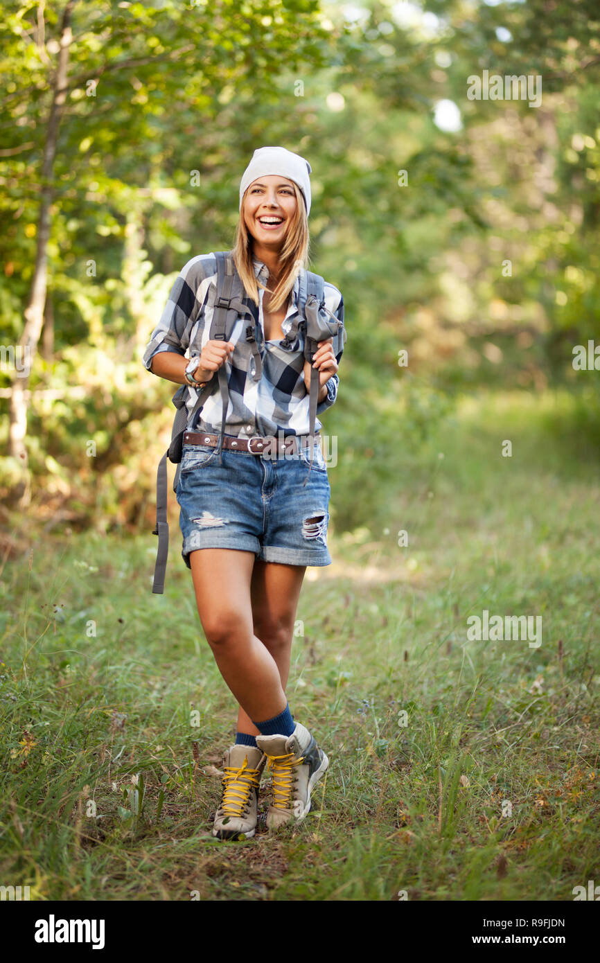 pretty girl hiker in a forest, wearing hat, shirt and shorts Stock ...
