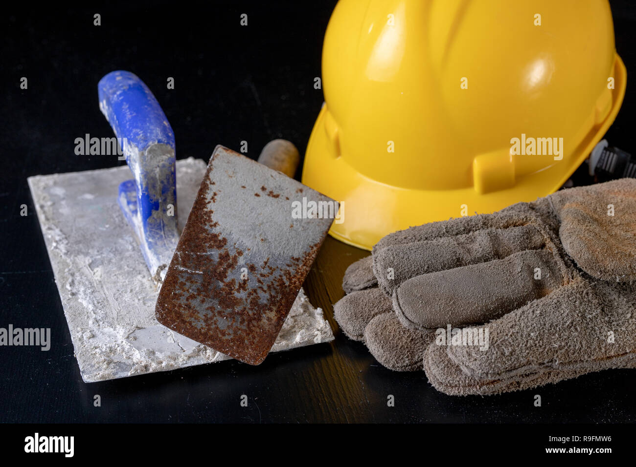 Tools for bricklayer and helmet on a black table. Accessories for ...