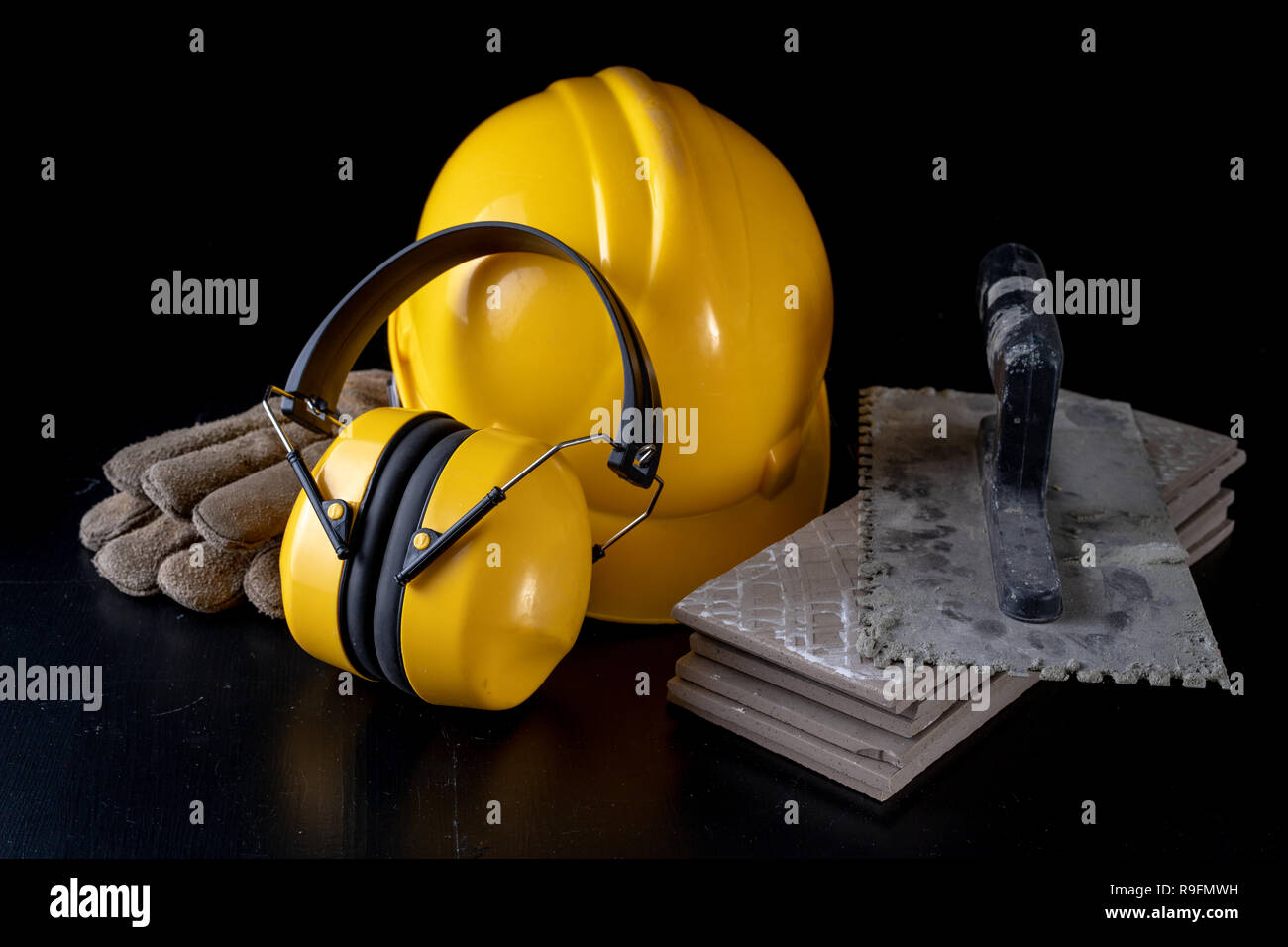Tools for bricklayer and helmet on a black table. Accessories for ...