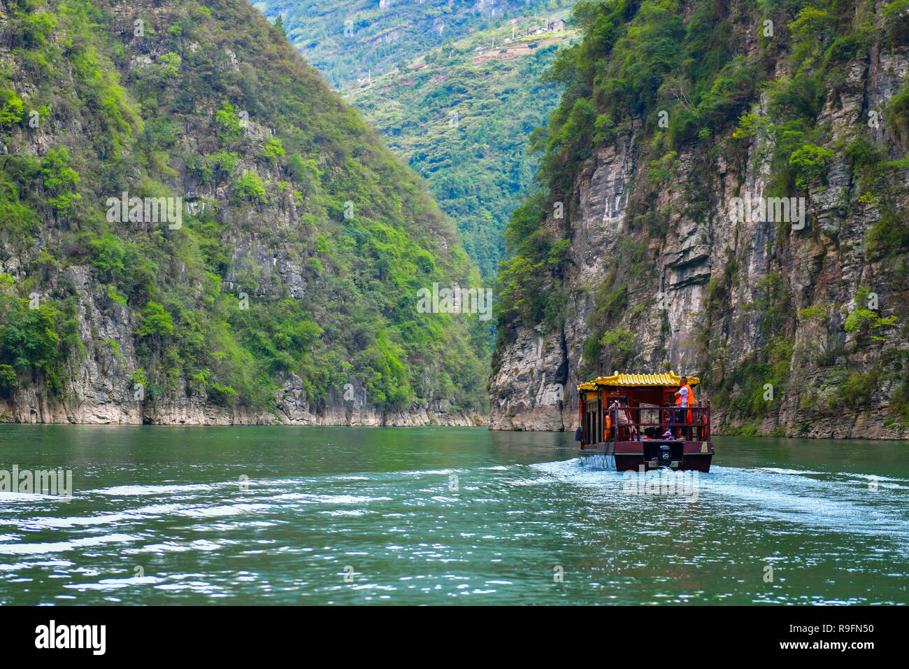 Small tourist ferry cruising up tributary of the Yangtze River at ...
