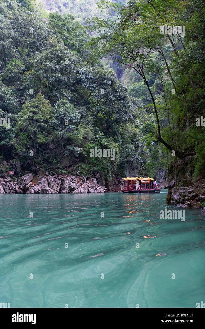 Small tourist ferry cruising up tributary of the Yangtze River at ...