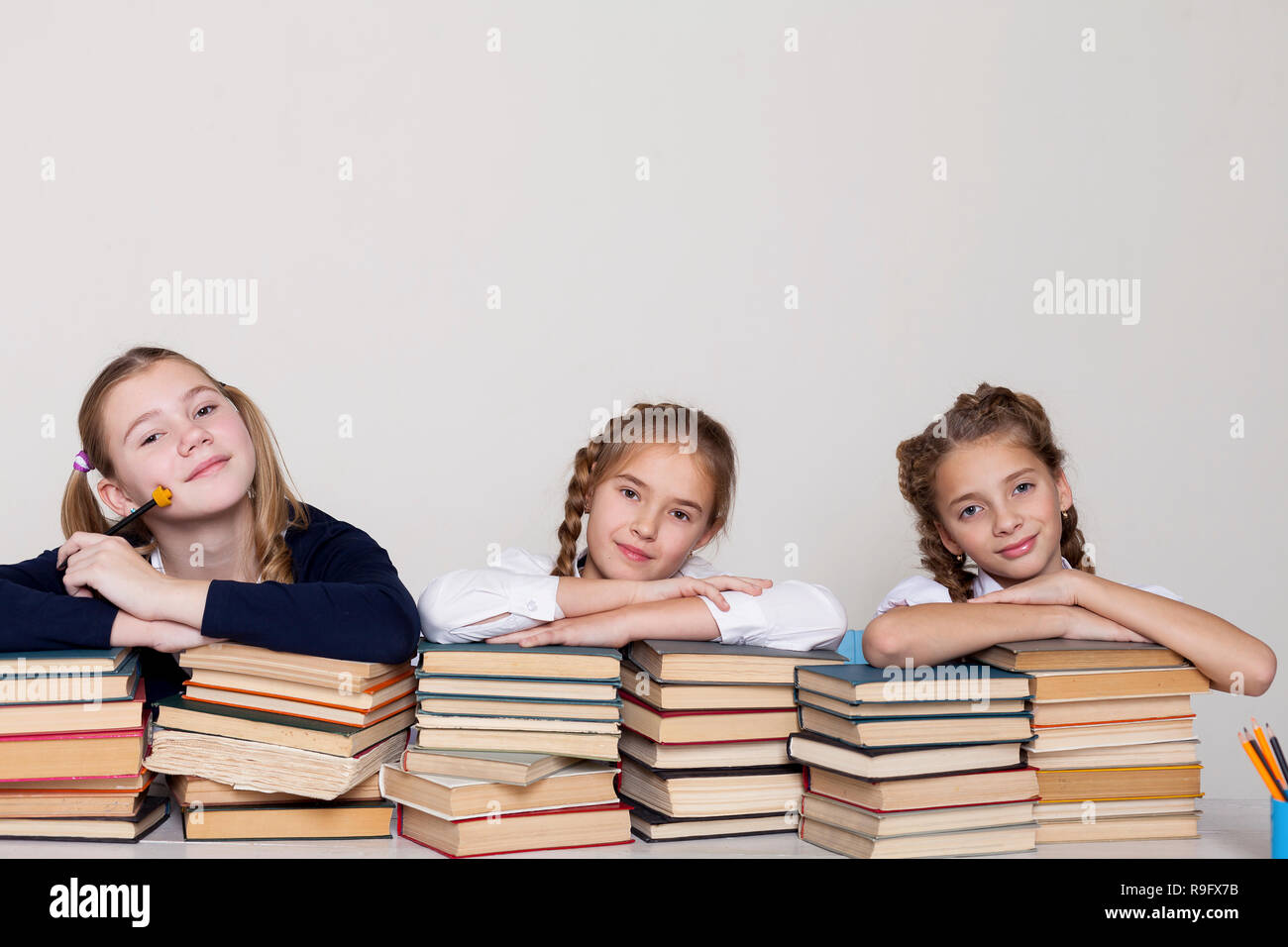 three girls in the classroom studying many books Stock Photo - Alamy