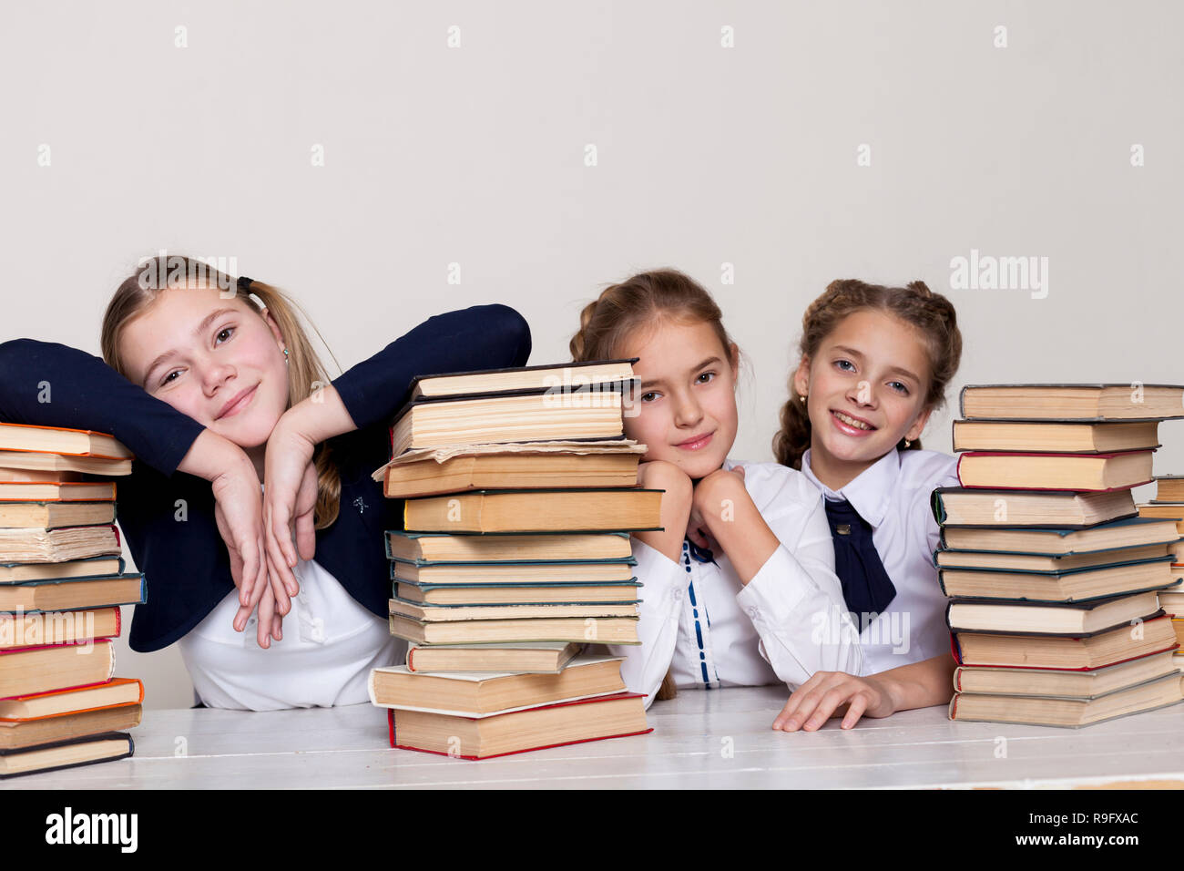 three girls in the classroom studying many books Stock Photo - Alamy