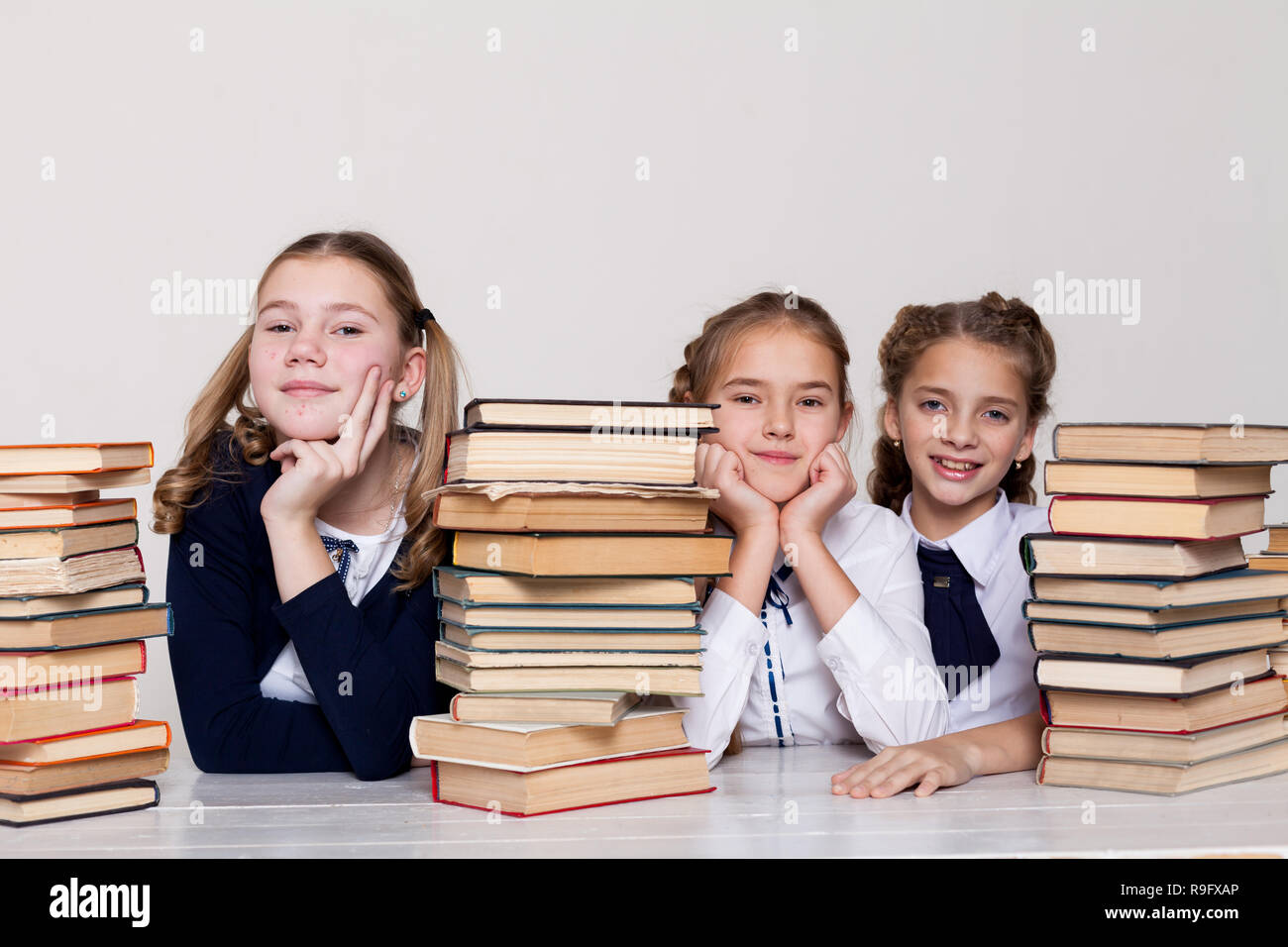 three girls in the classroom studying many books Stock Photo - Alamy