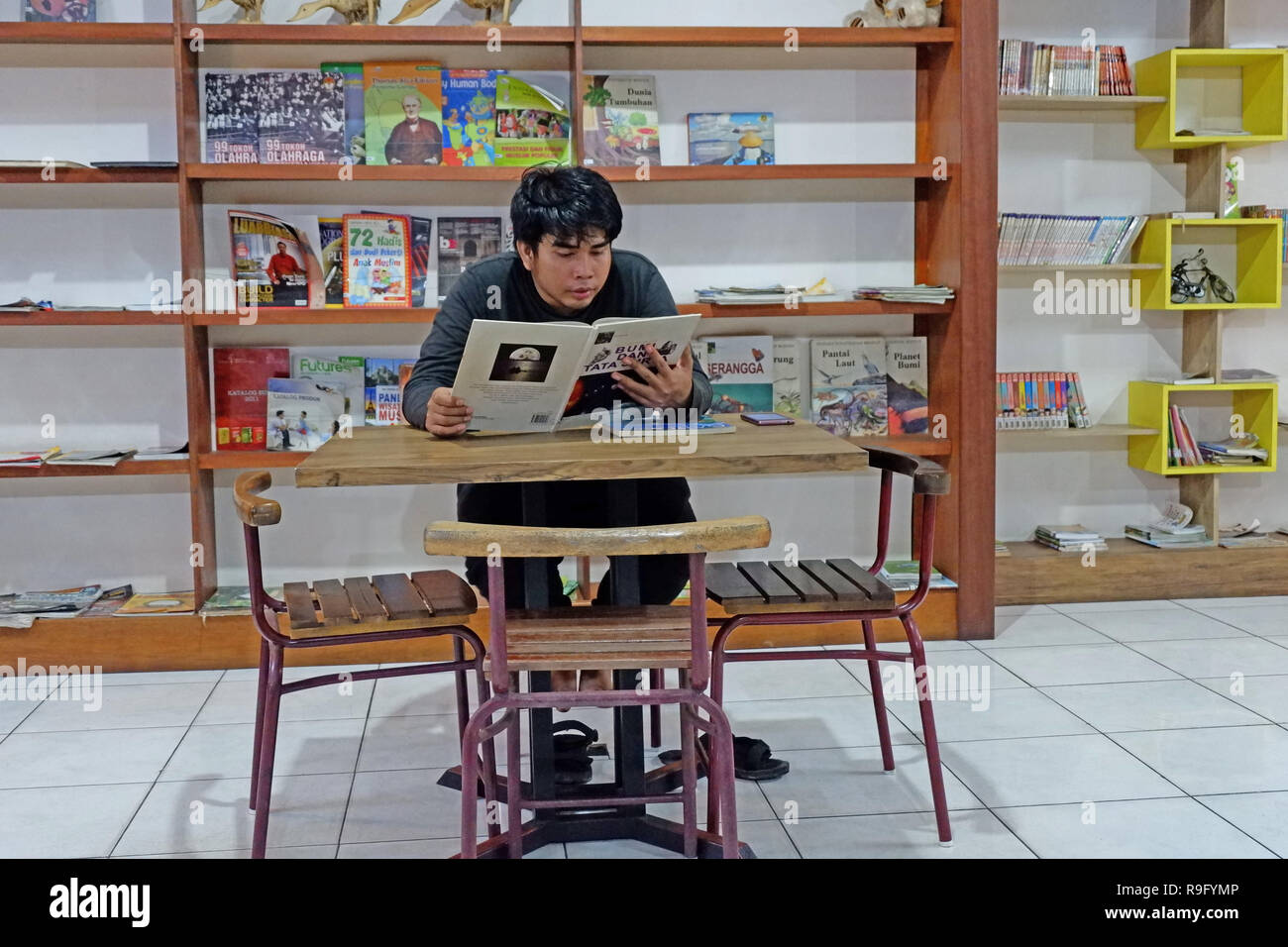 man reading a book in library Stock Photo - Alamy