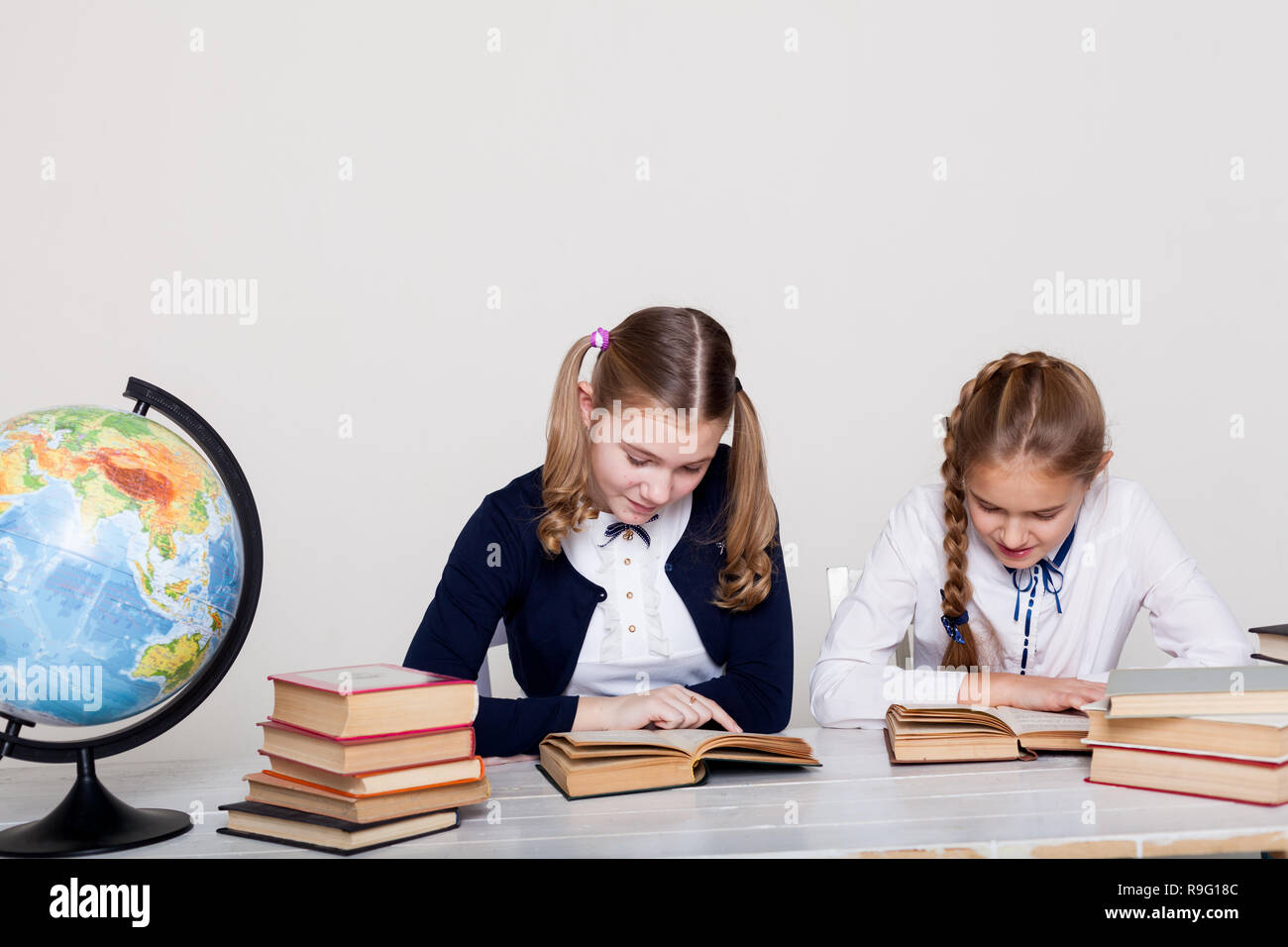 two girls in the classroom Learn lesson books at her desk globe Stock ...