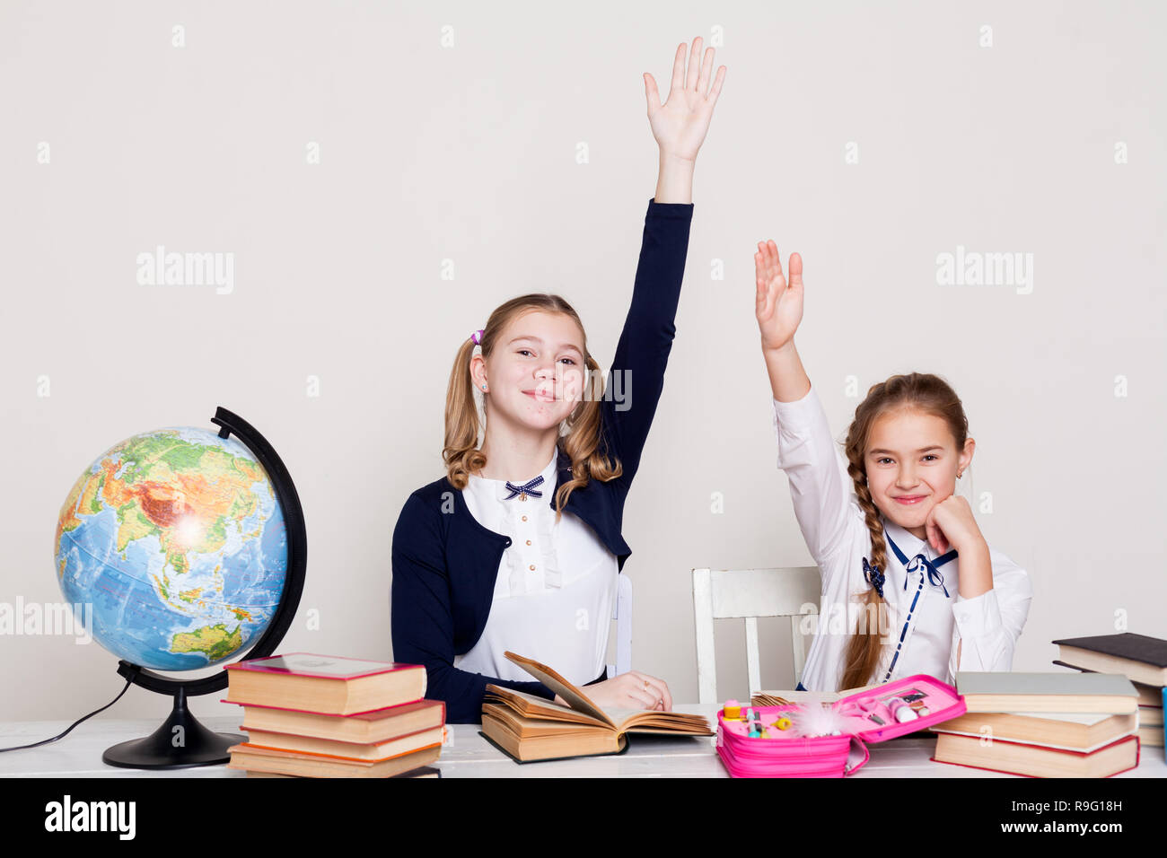 two girls in the classroom Learn lesson books at her desk globe Stock ...