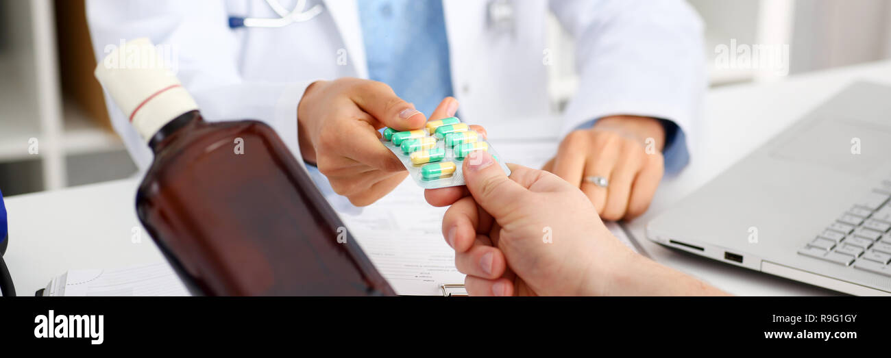 Alcoholic hold in arm empty bottle and medication Stock Photo - Alamy