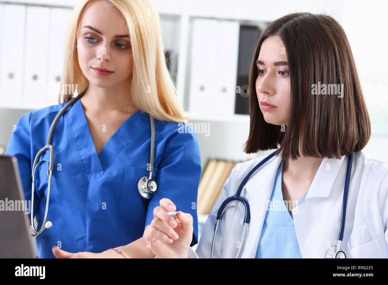 Group of doctors using laptop pc sitting Stock Photo - Alamy