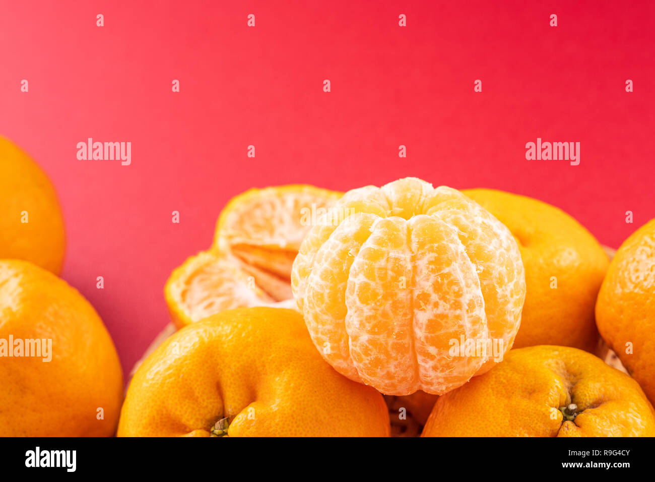 Beautiful and delicous tangerine isolated on red background with bamboo ...