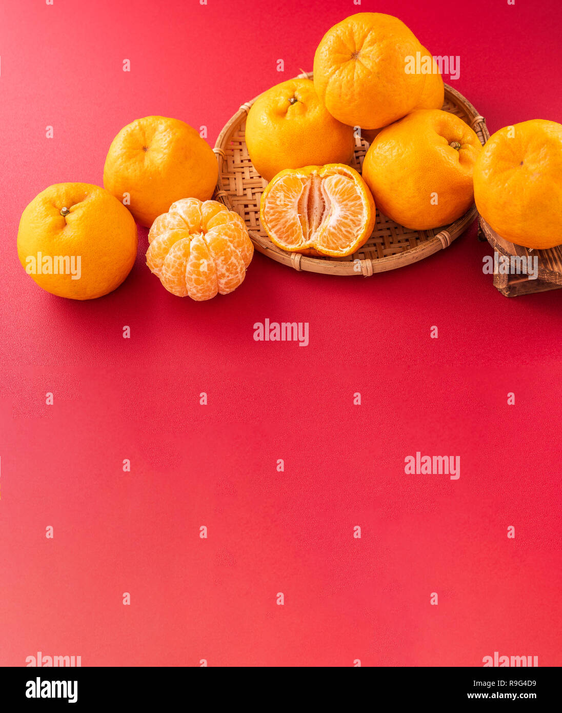 Beautiful and delicous tangerine isolated on red background with bamboo ...
