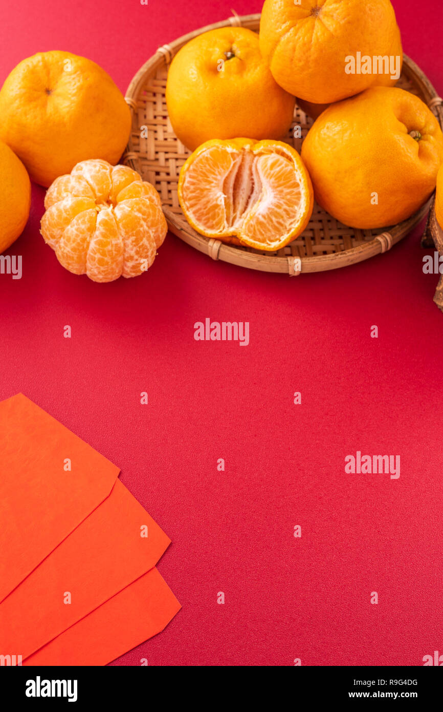 Beautiful and delicous tangerine isolated on red background with bamboo ...