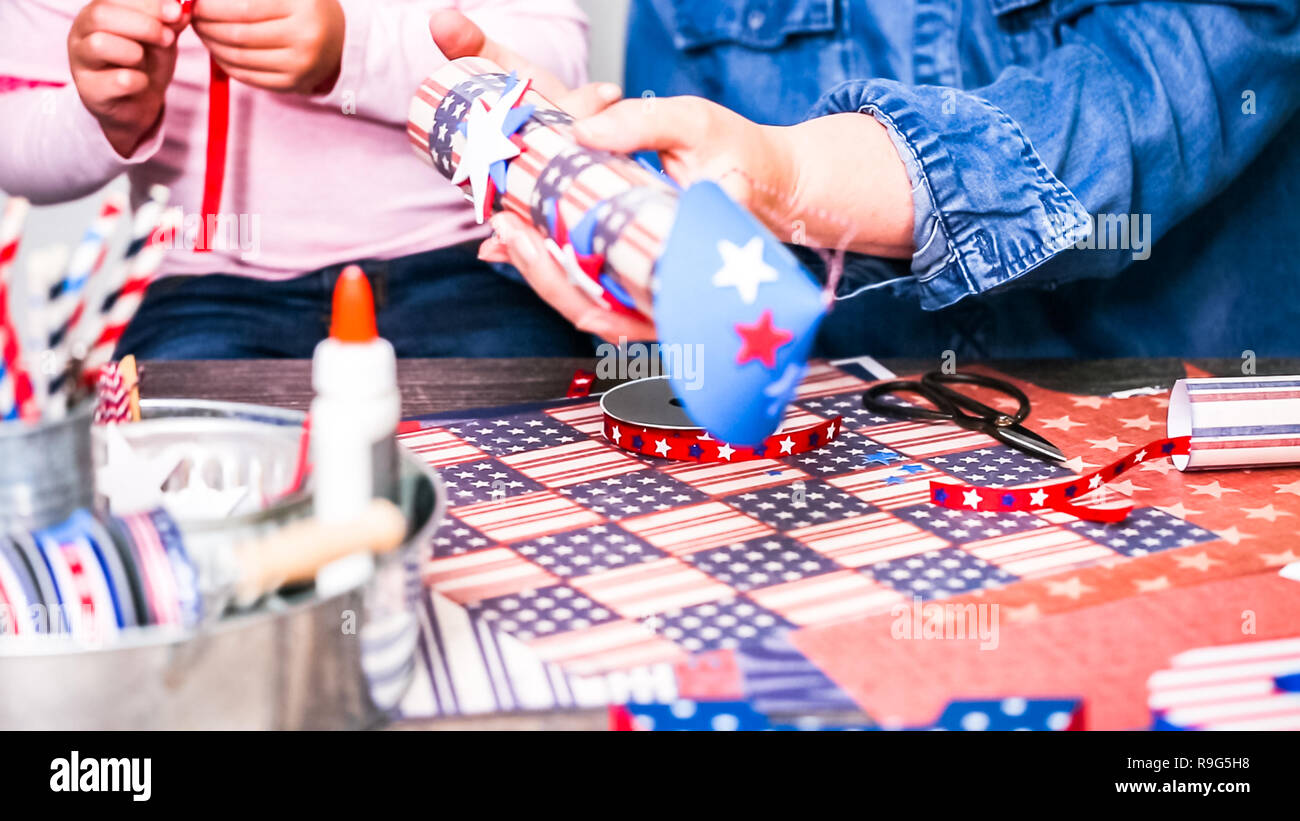 Step by step. Mother and daughter making paper firecrackers for July ...