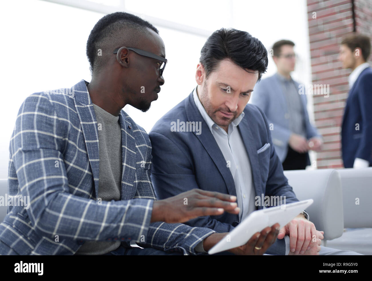 two business partners use a digital tablet Stock Photo - Alamy