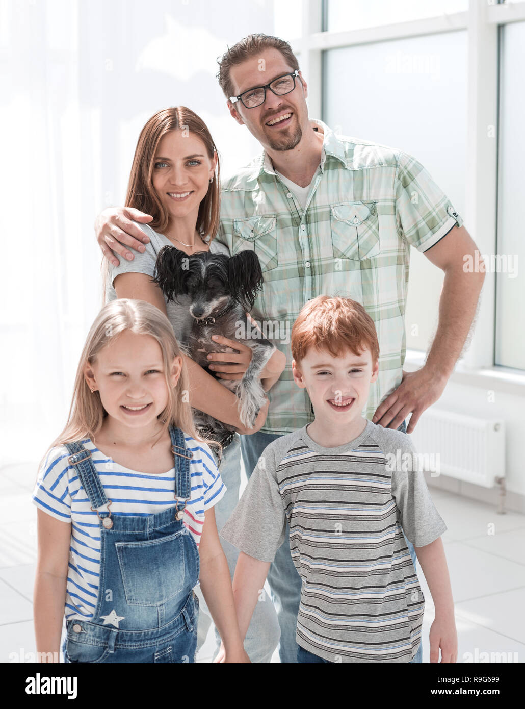 happy family on the background of a bright living room Stock Photo - Alamy