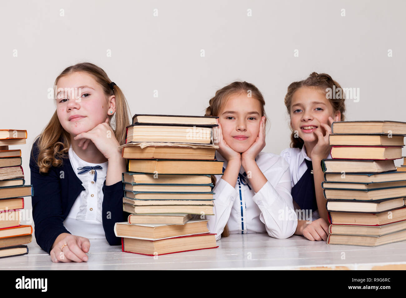three girls in the classroom studying many books Stock Photo - Alamy