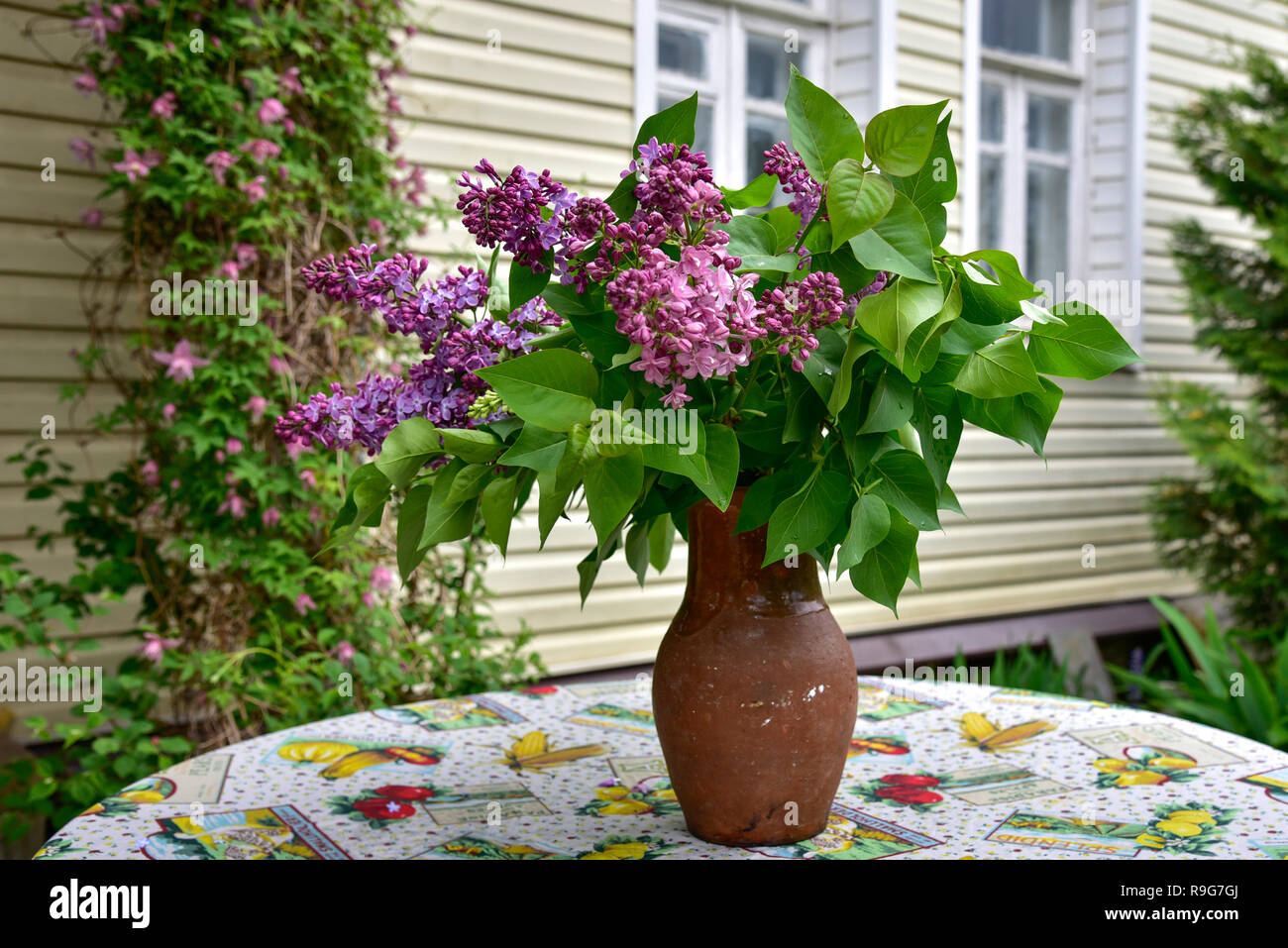 Clay pitcher with lilac flowers on the terrace in summer Stock Photo ...