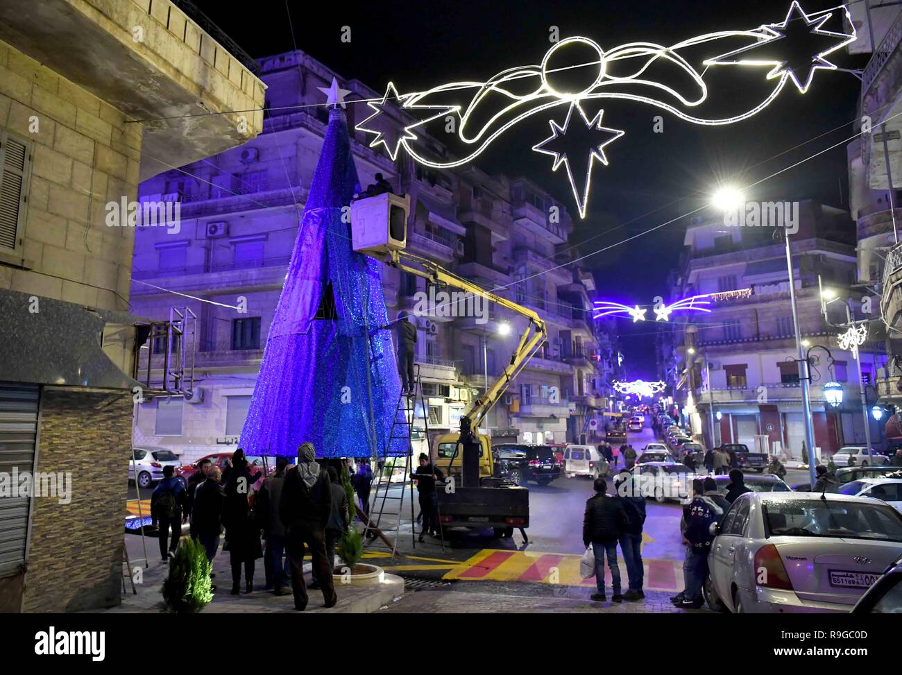 Aleppo, Syria. 23rd Dec, 2018. People set up a Christmas tree at the ...