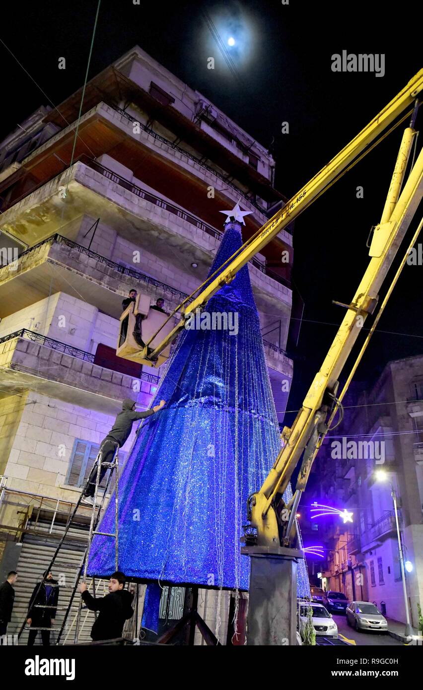 Aleppo, Syria. 23rd Dec, 2018. People set up a Christmas tree at the ...
