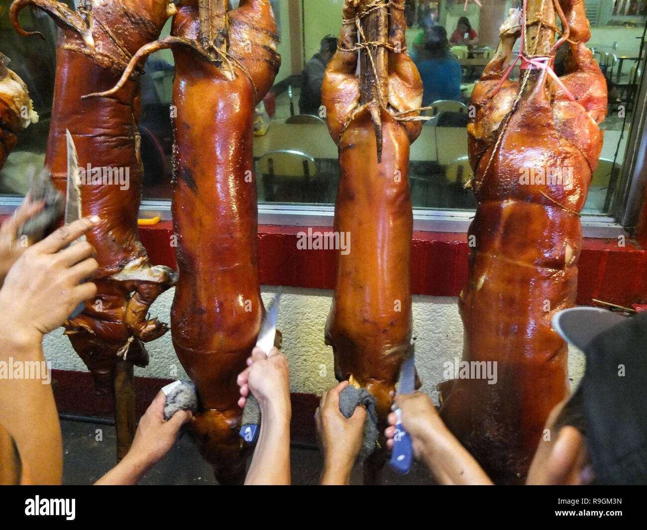 Lechon workers putting away excess pig's fur by using their knives. The ...