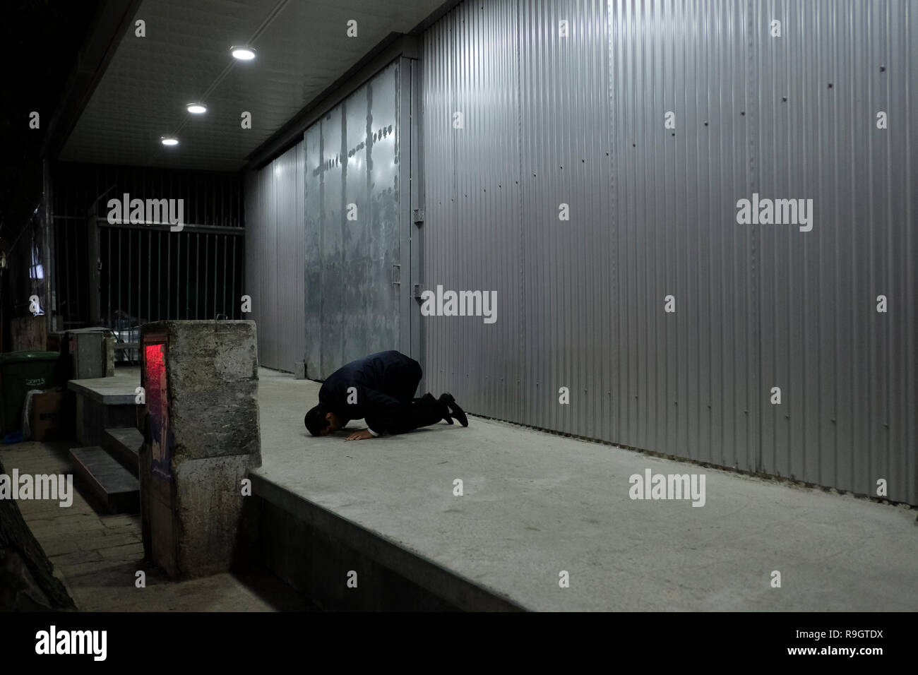 A Muslim man bow in prayer in the street in the city of Nazareth ...