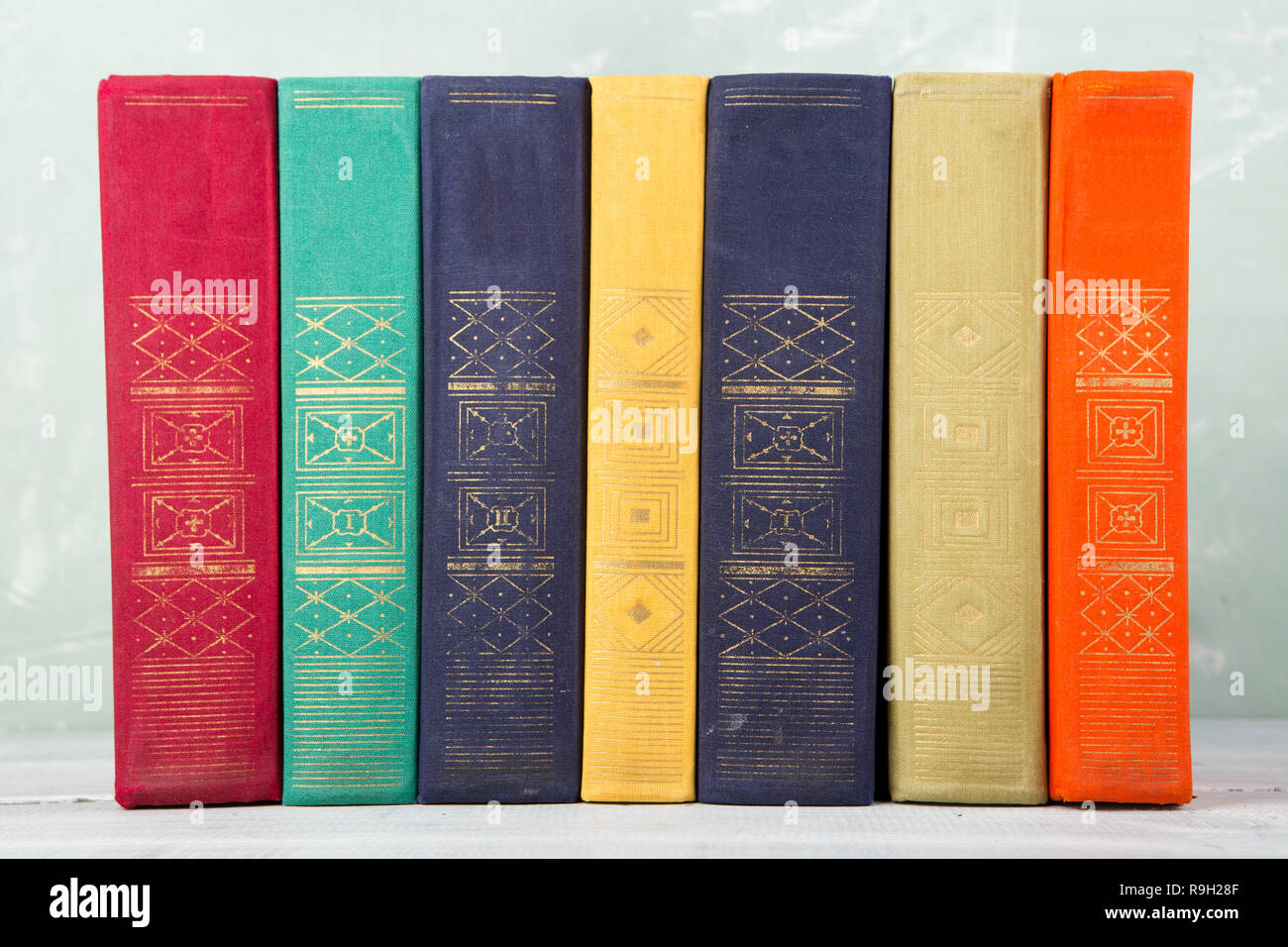 A stack of old colored books on shelf and green background Stock Photo ...