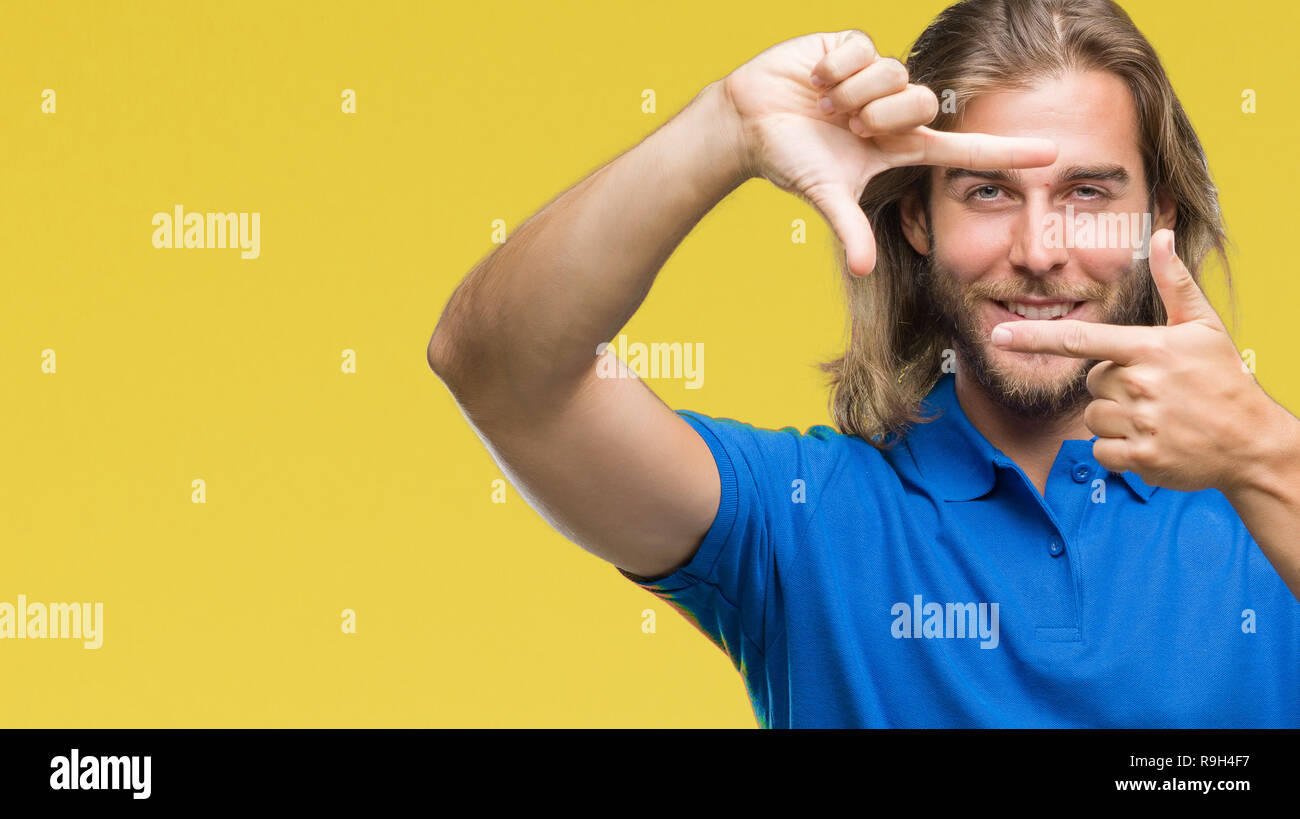 Young handsome man with long hair over isolated background smiling ...